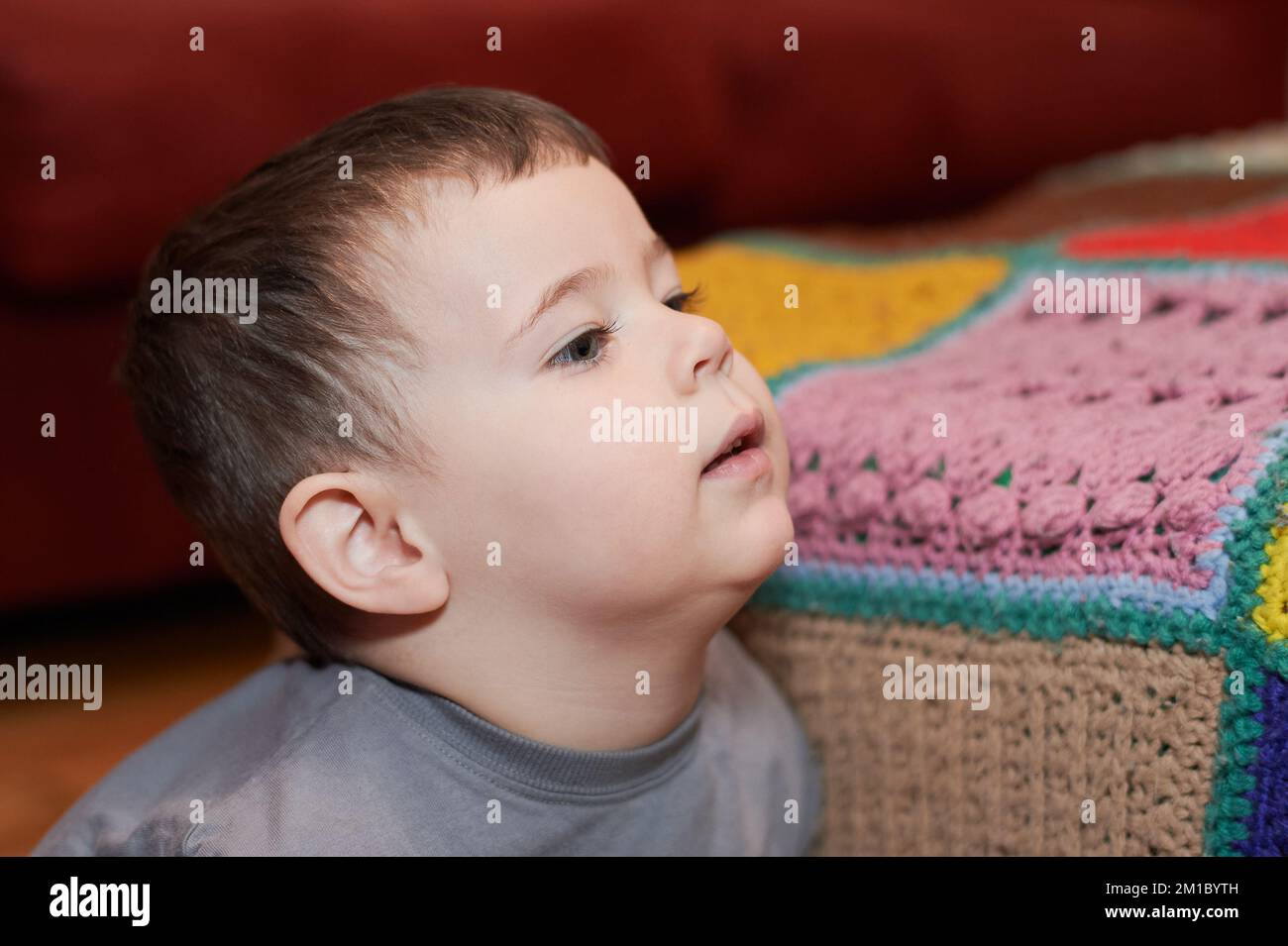 Expressive young boy watching cartoons in the livingroom Stock Photo ...