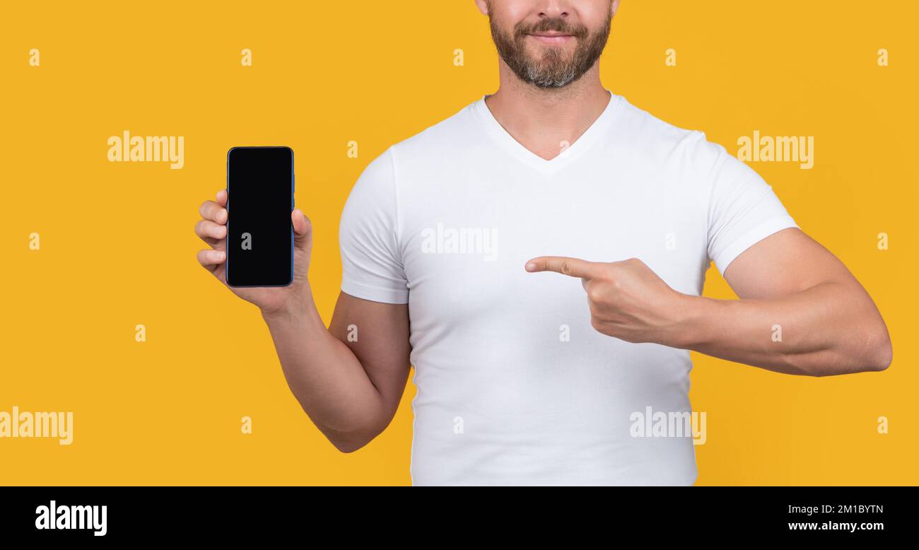 cropped man showing phone screen in studio. man showing screen of phone ...