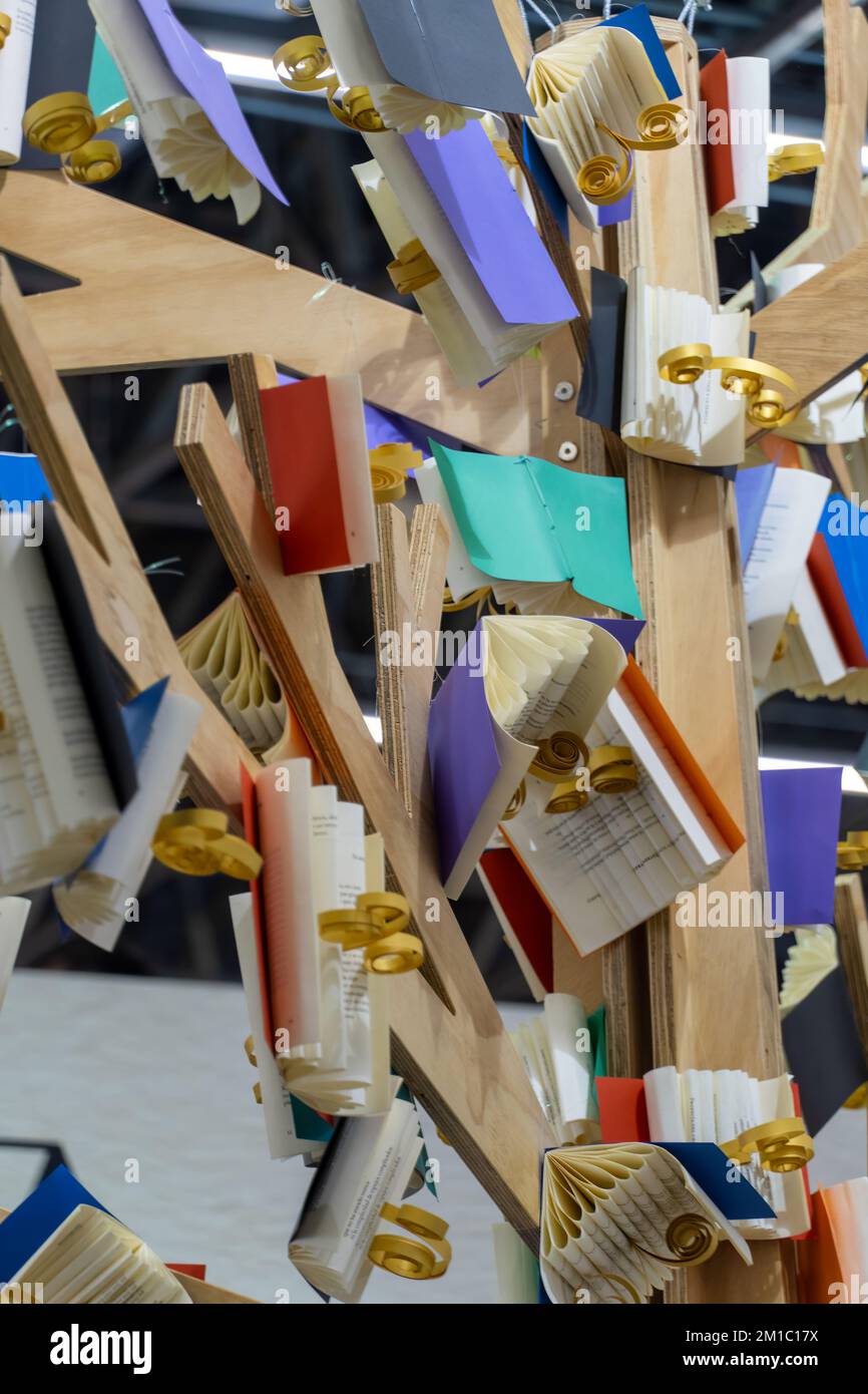 The book is hanging on a tree branch with green foliage. From the book ...