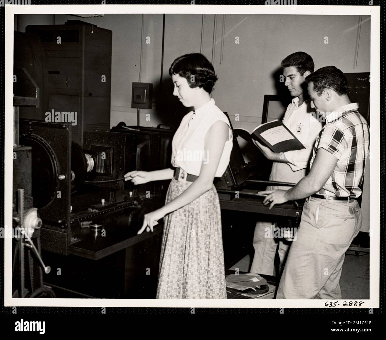 Woman and two men testing machine , Armories, Ordnance industry ...