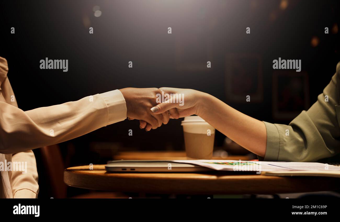 Two Businesswoman shaking hands as sign of successful negotiations ...