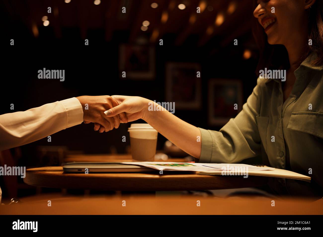 Two Businesswoman shaking hands as sign of successful negotiations ...