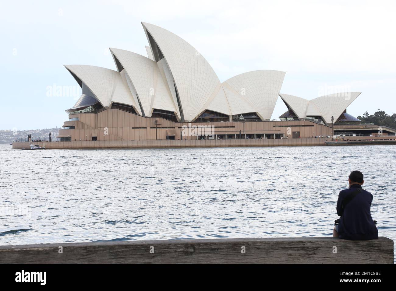 A man on his own sits in front of the Sydney Opera House Stock Photo ...