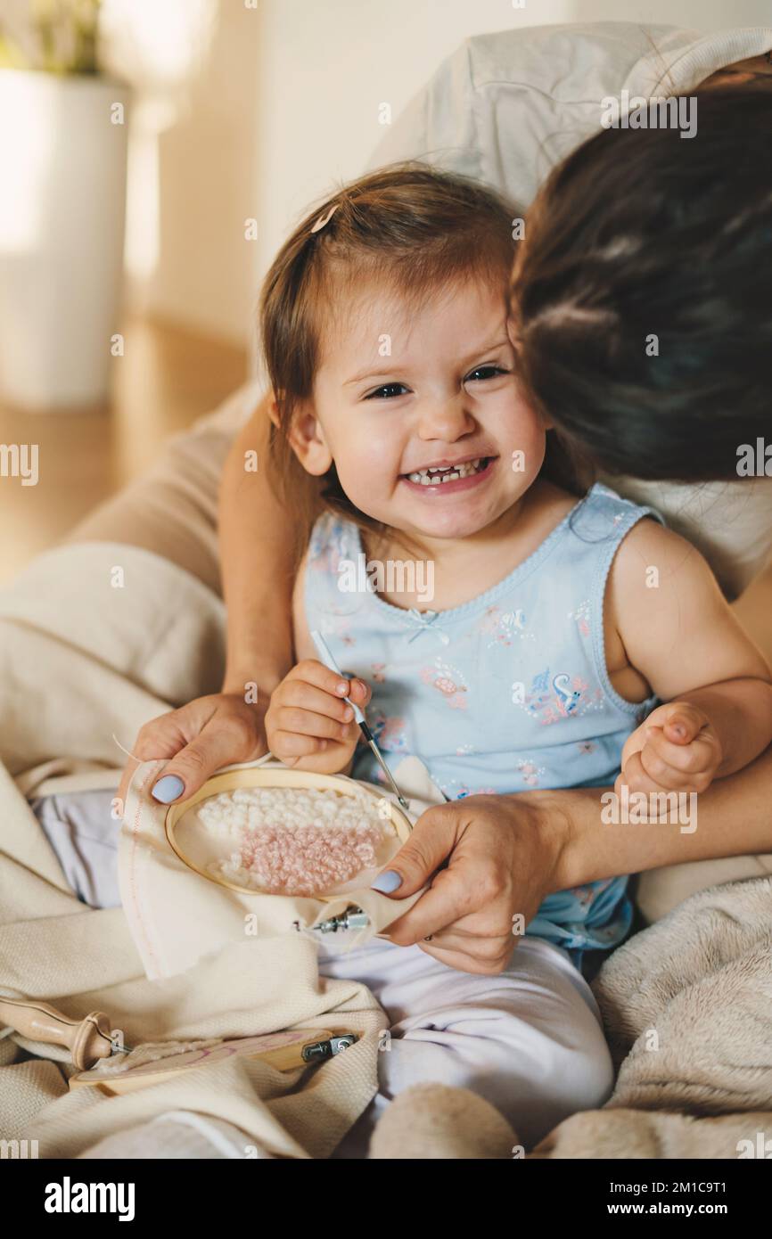 Mother and daughter spending time together at home, doing handicrafts ...