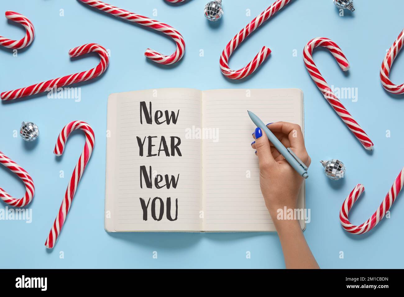 Woman making to-do list for year 2023 on light blue background, top ...