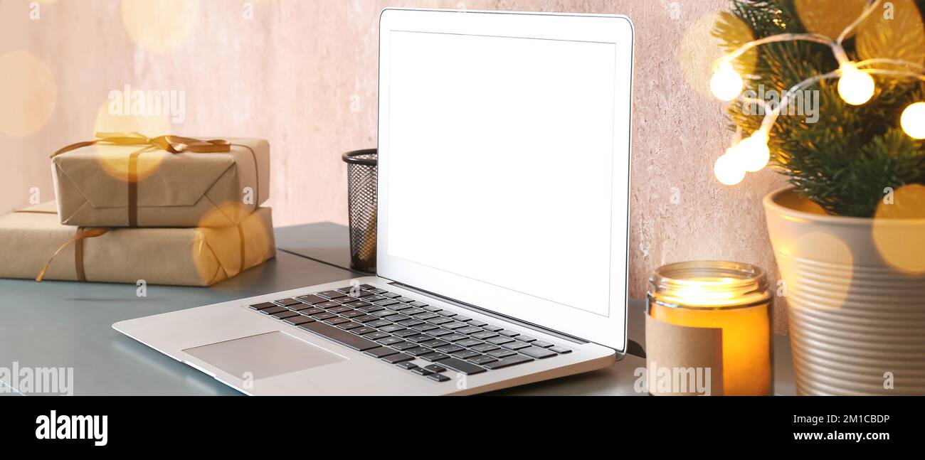Laptop and Christmas gifts at workplace in office Stock Photo - Alamy