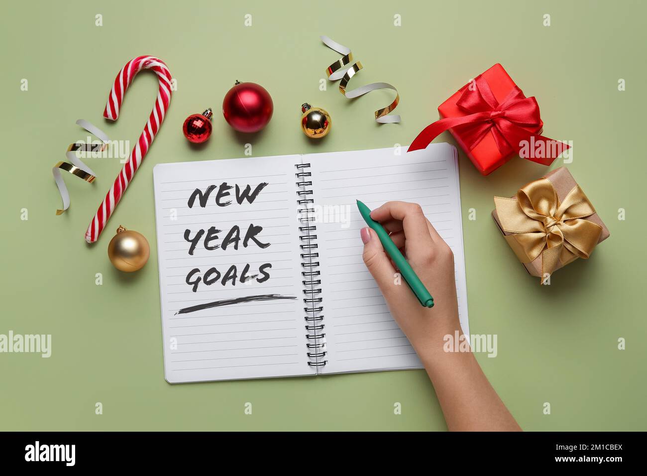 Woman making to-do list for year 2023 on color background, top view ...