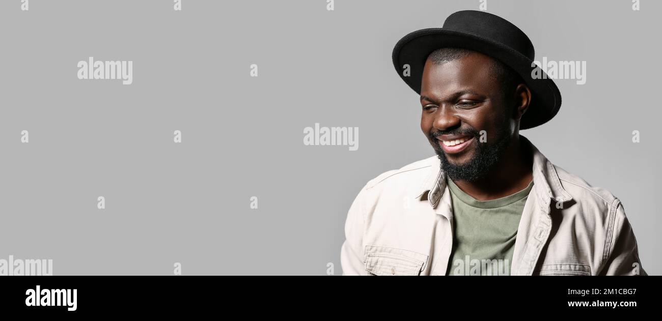 Portrait of happy African-American man on grey background with space ...