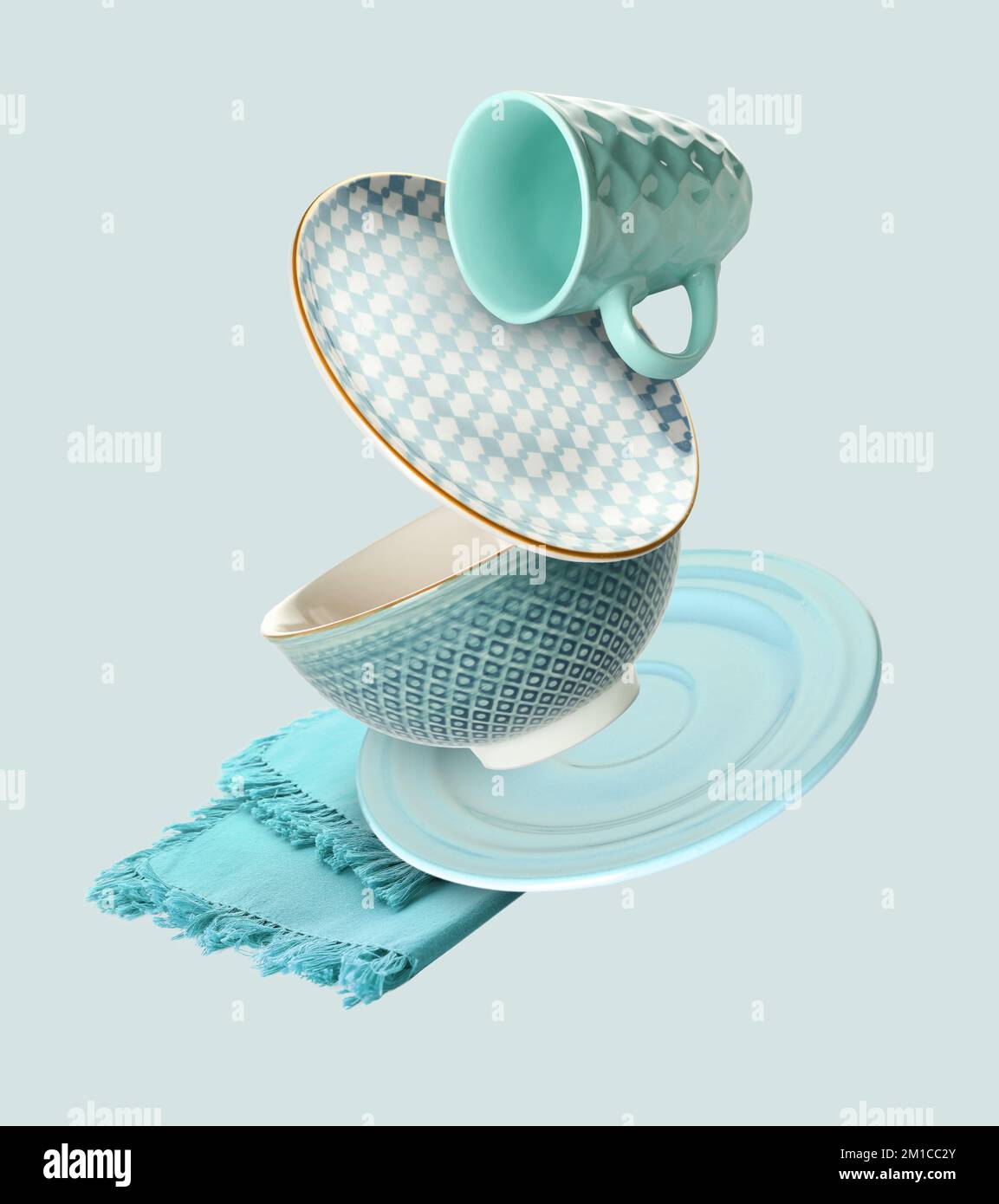 Flying clean dishes and napkin on light background Stock Photo - Alamy