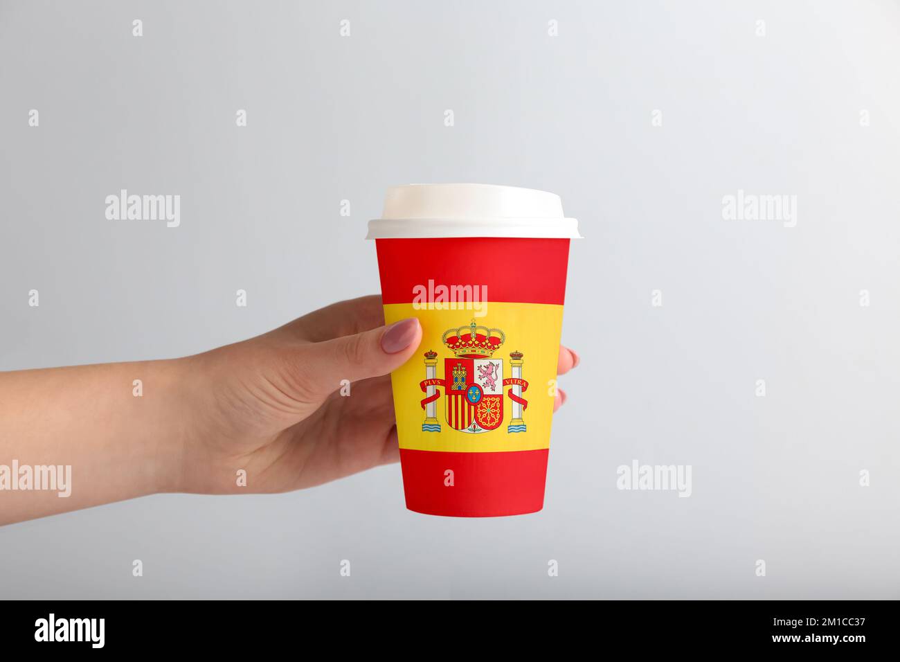 Woman holding takeaway coffee cup with print of Spanish flag on light ...