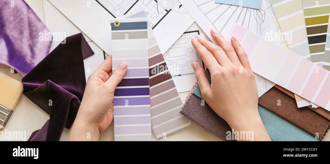 Female designer with paint color palettes at table, top view Stock ...