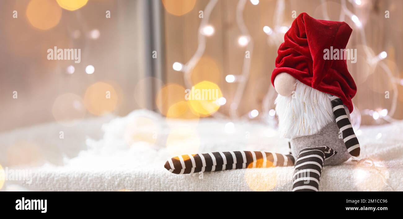 Christmas gnome on window sill with glowing lights. Banner for design ...