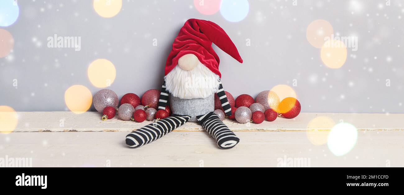 Christmas gnome with decorations on light wooden background Stock Photo ...