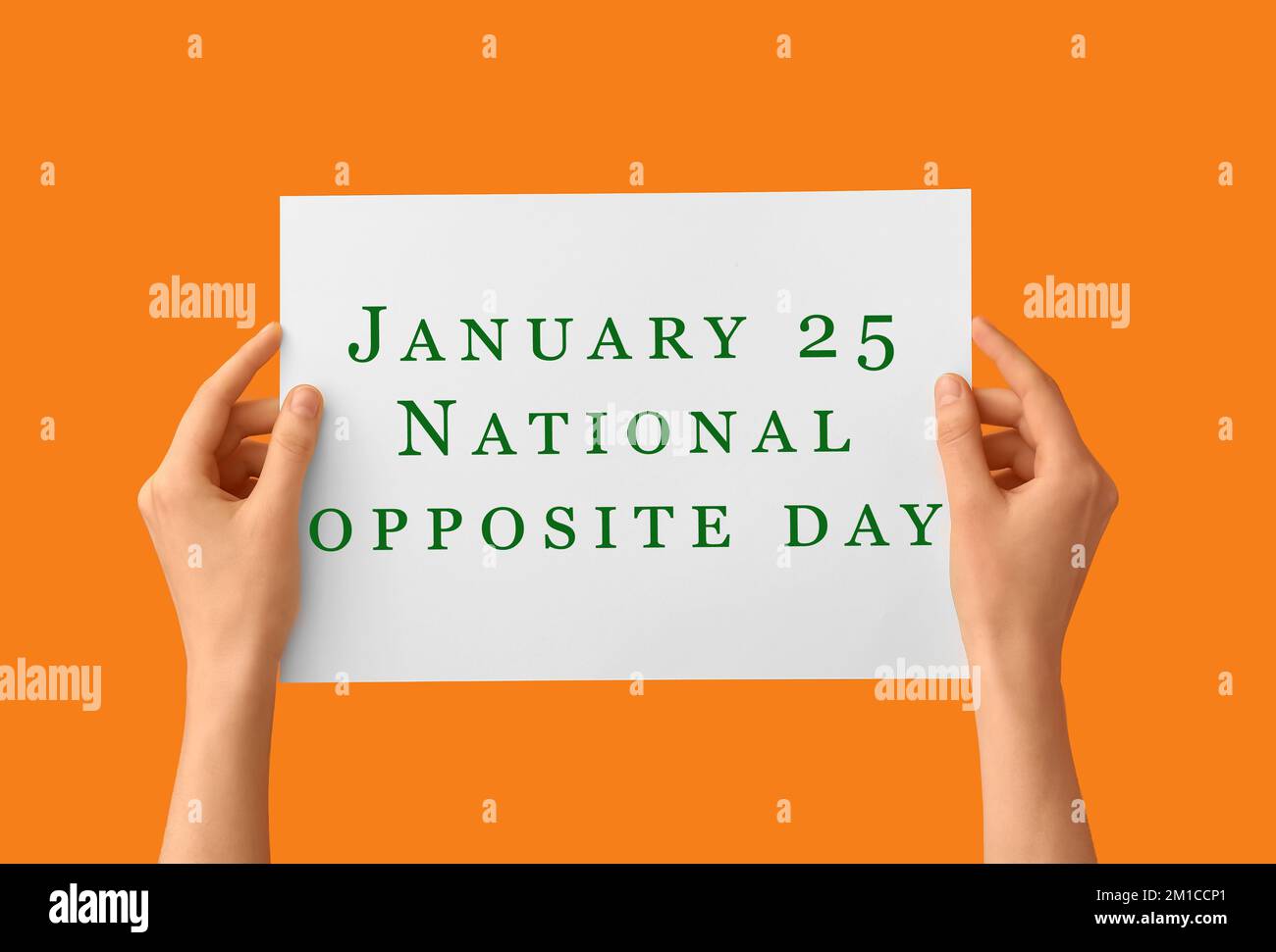 Female hands holding paper sheet with text JANUARY 25 NATIONAL OPPOSITE ...