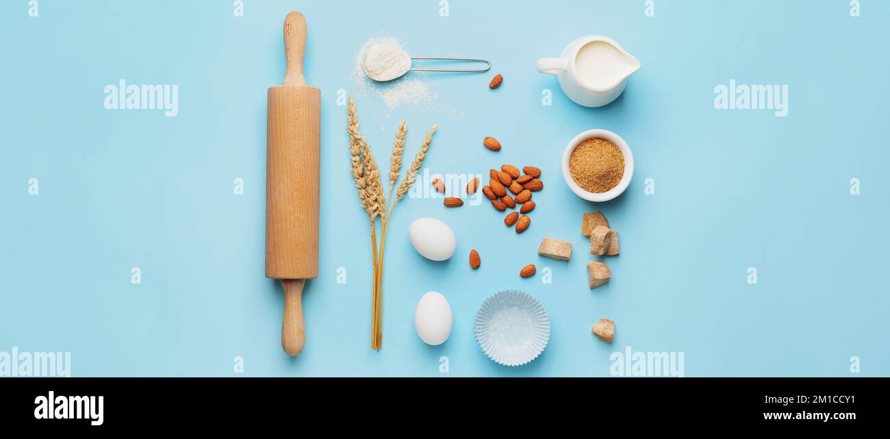 Ingredients for preparing bakery and rolling pin on light blue ...