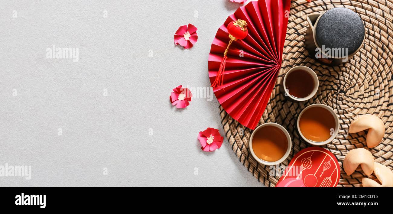 Chinese fan, tea and fortune cookies on light background with space for ...