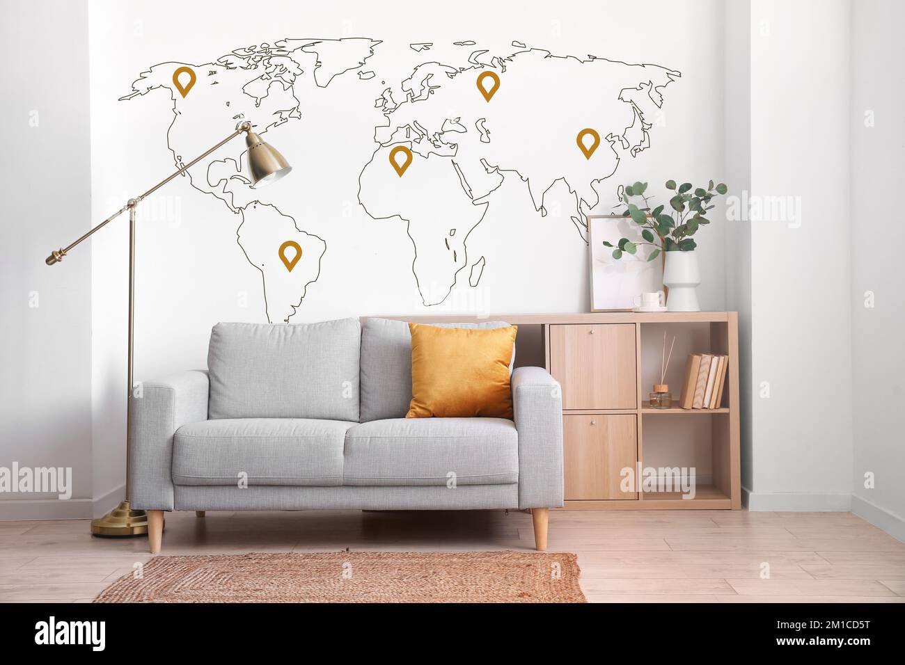 Interior of light living room with grey sofa and printed world map on ...