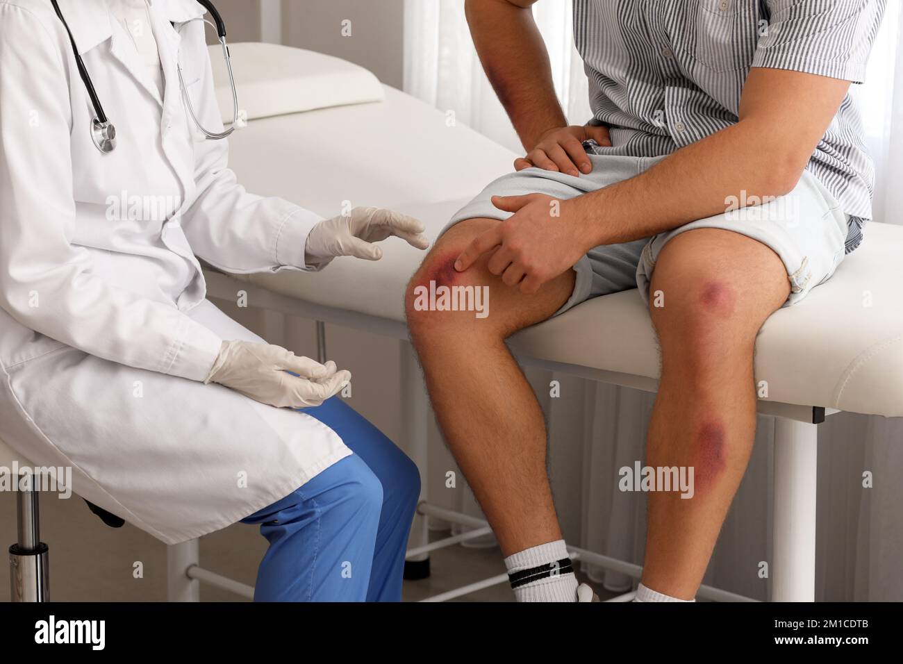 Doctor examining man with bruises in clinic Stock Photo - Alamy