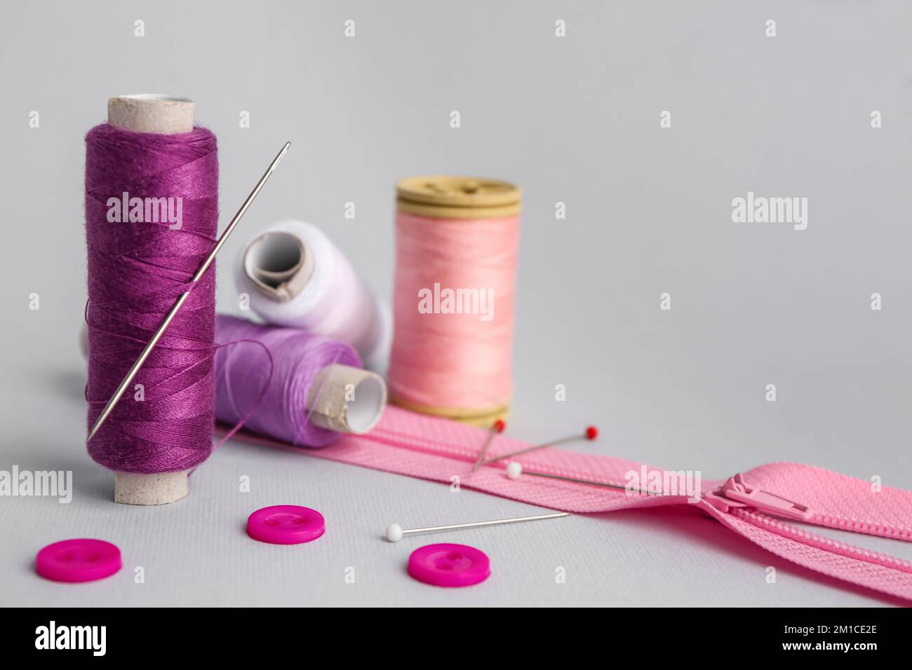 Set of sewing supplies with thread spools on grey background Stock ...