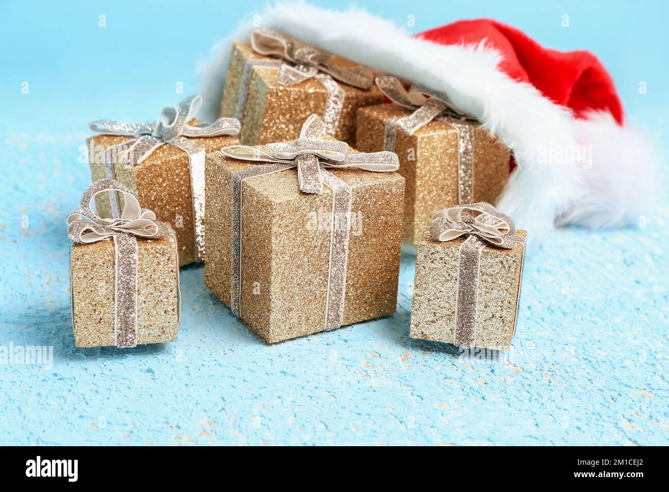 Santa hat with different Christmas gifts on color background Stock ...
