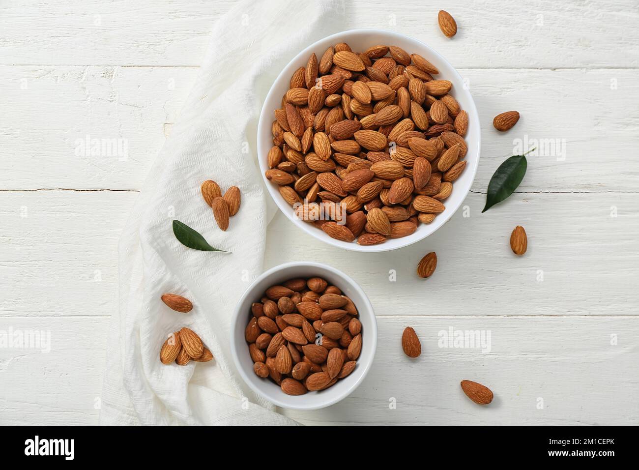 Bowls of almonds on white wooden table Stock Photo - Alamy