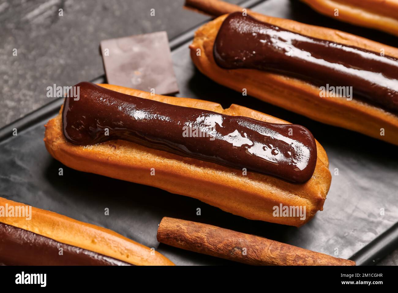 Board with tasty chocolate eclairs, closeup Stock Photo - Alamy