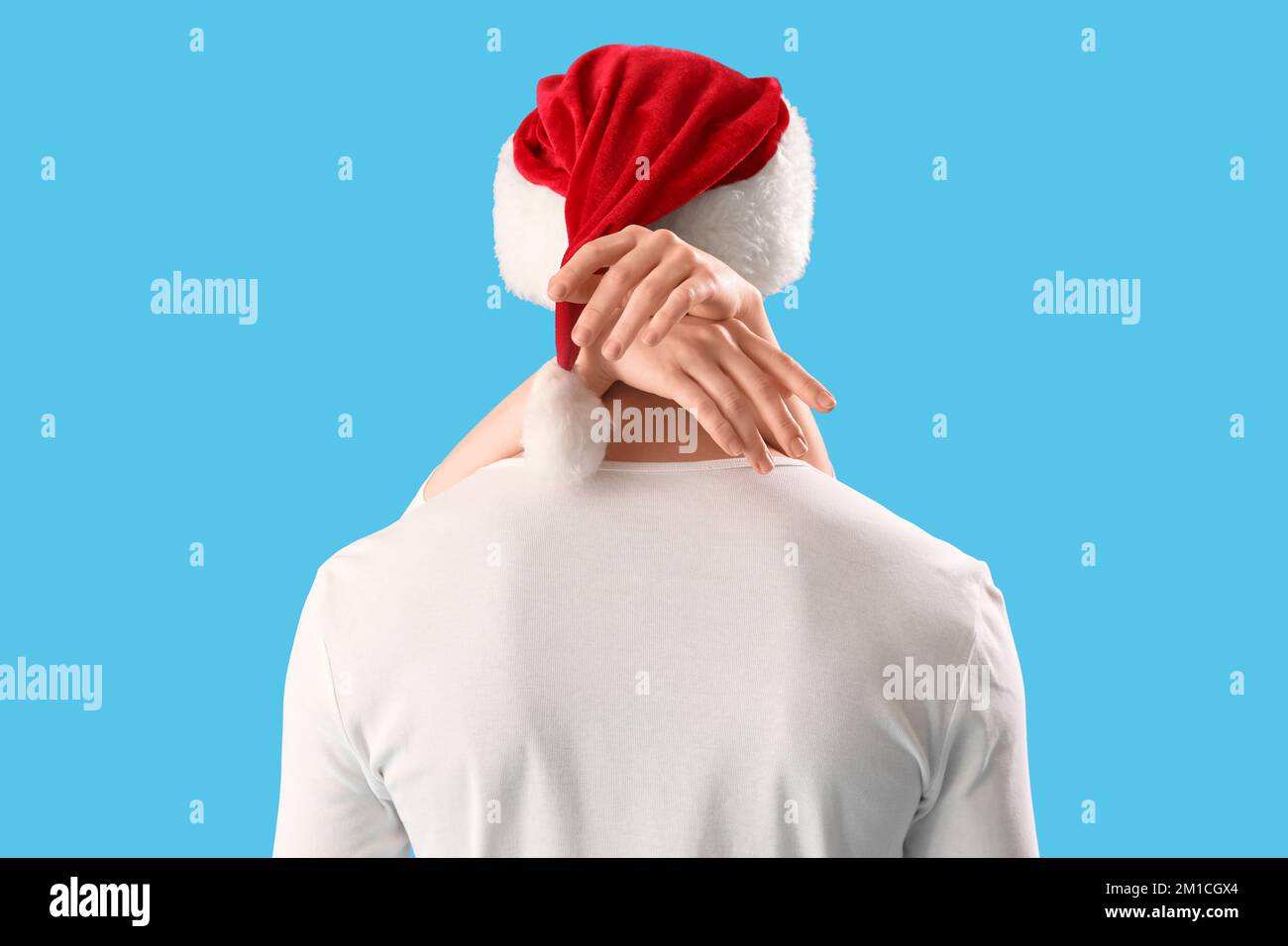 Young couple in Santa hat hugging on blue background, back view Stock ...
