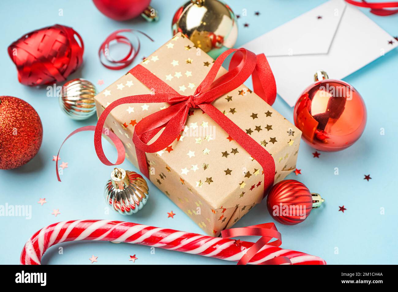 Gift box with Christmas balls, envelope and candy cane on blue ...