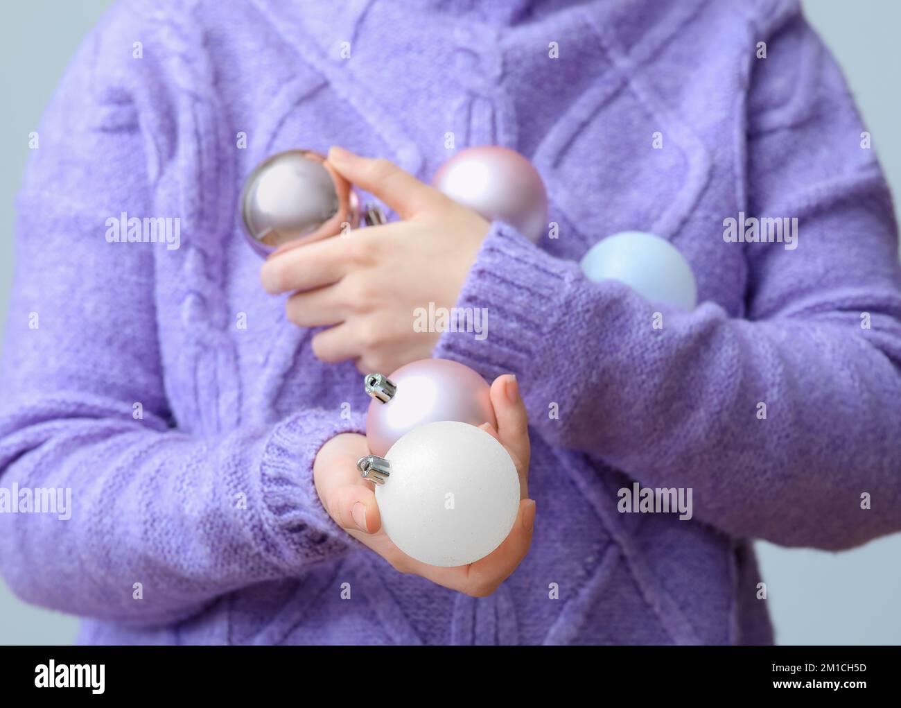 Woman in lilac sweater with Christmas balls, closeup Stock Photo - Alamy