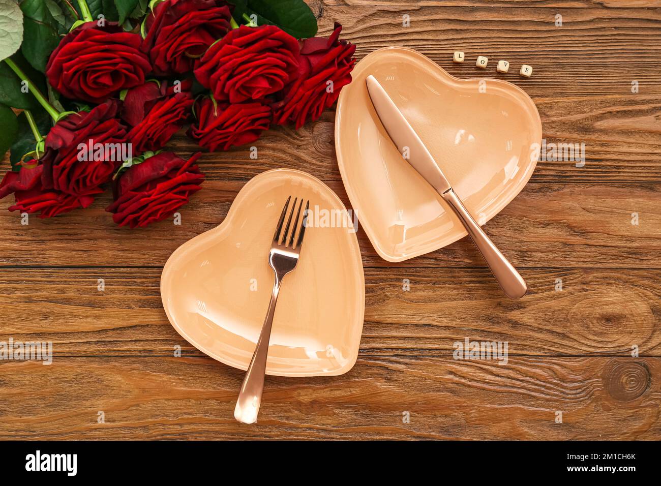 Table setting for Valentine's Day with word LOVE and roses on wooden ...