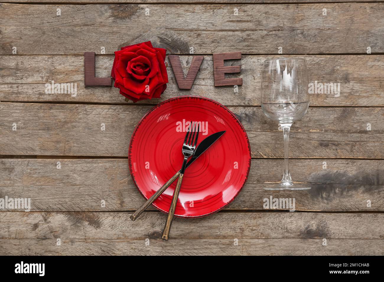 Table setting for Valentine's Day with word LOVE and rose on wooden ...