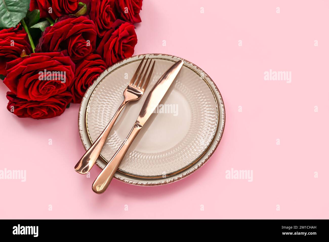 Table setting for Valentine's Day with red roses on pink background ...