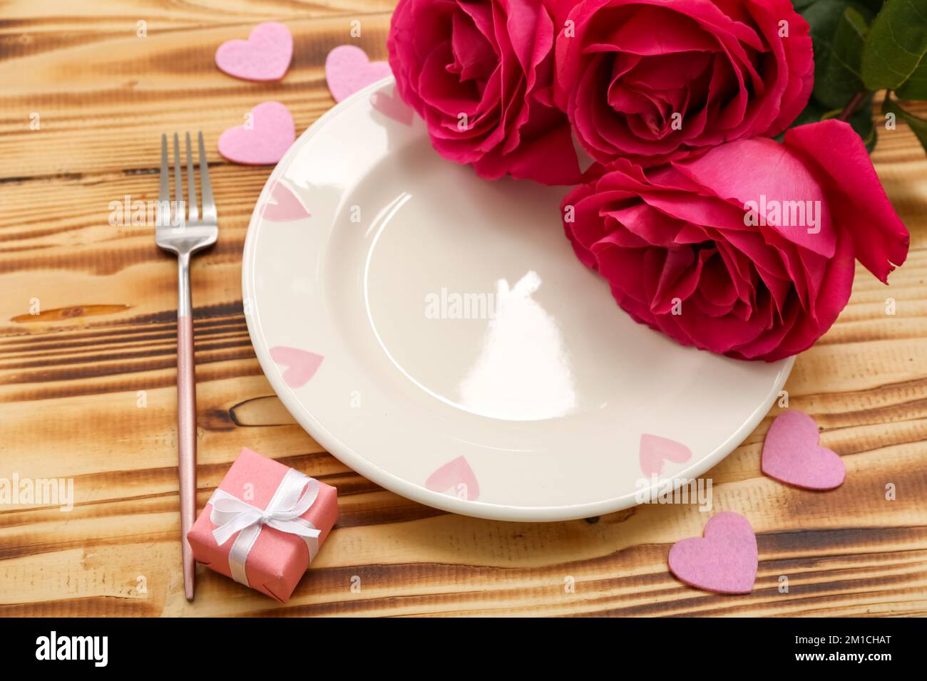 Table setting for Valentine's Day with hearts and roses on wooden ...