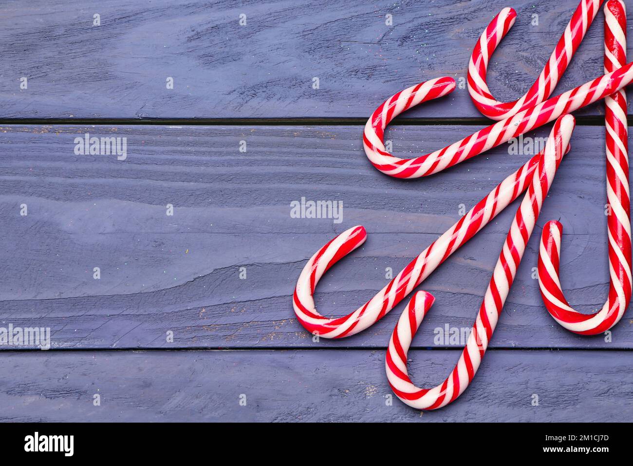 Sweet candy canes on color wooden background Stock Photo - Alamy