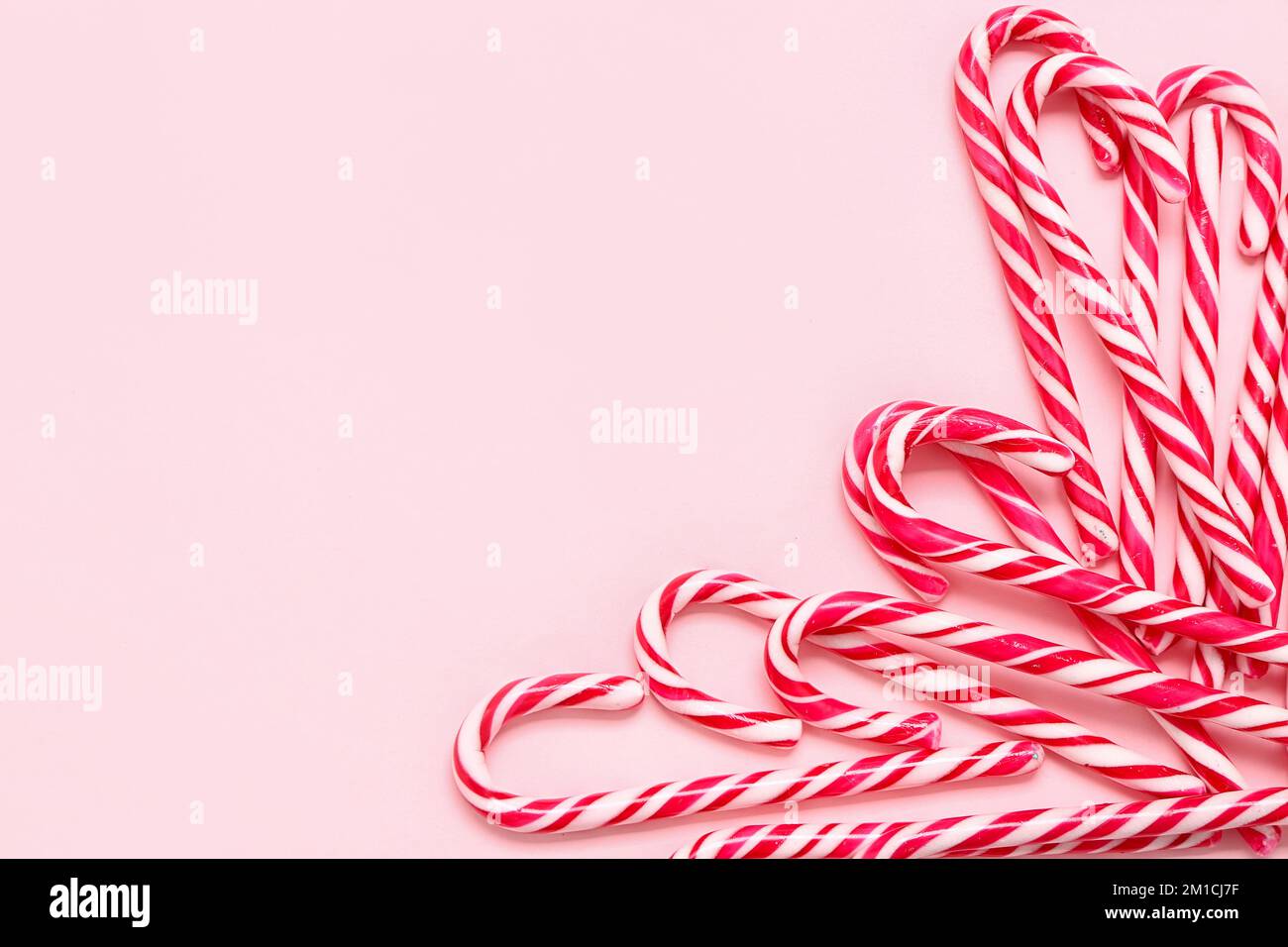 Delicious candy canes on pink background Stock Photo - Alamy