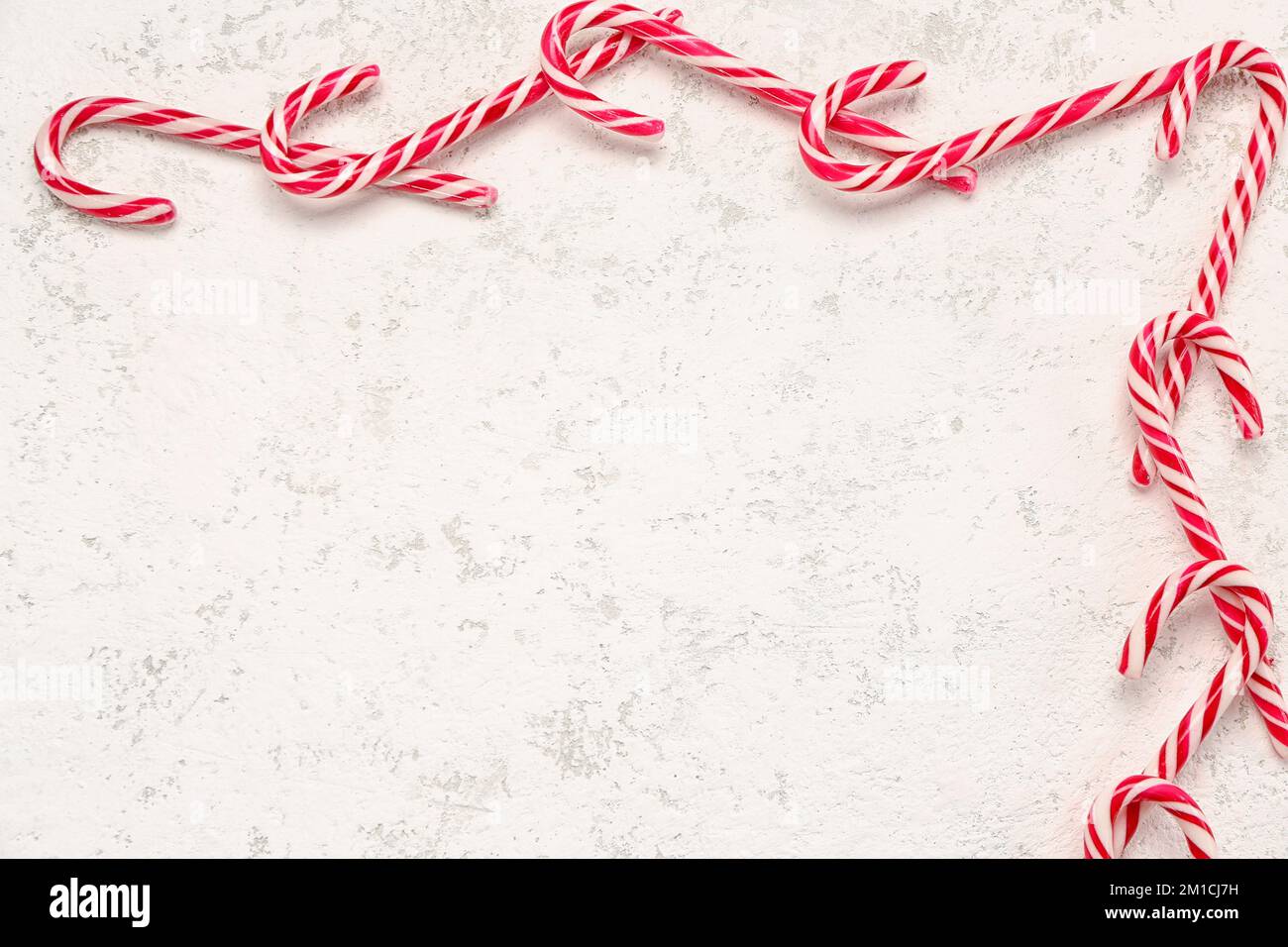 Composition with sweet candy canes on light background Stock Photo - Alamy