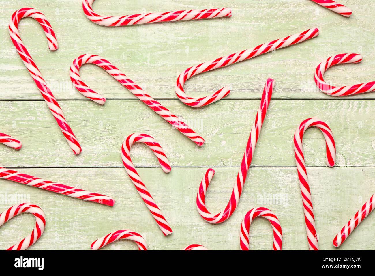 Sweet candy canes on color wooden background Stock Photo - Alamy