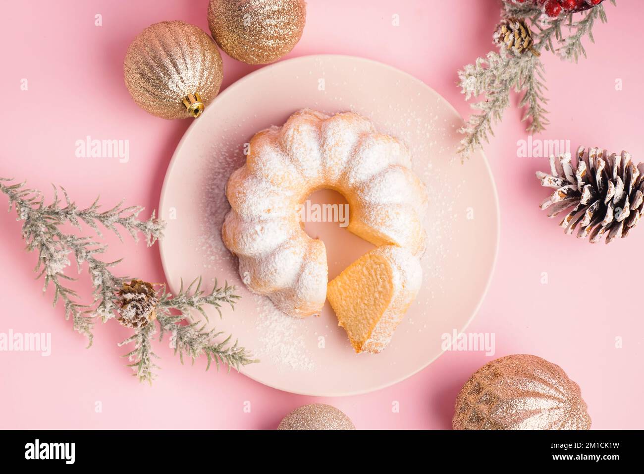 Plate with tasty Christmas cake and decorations on pink background ...