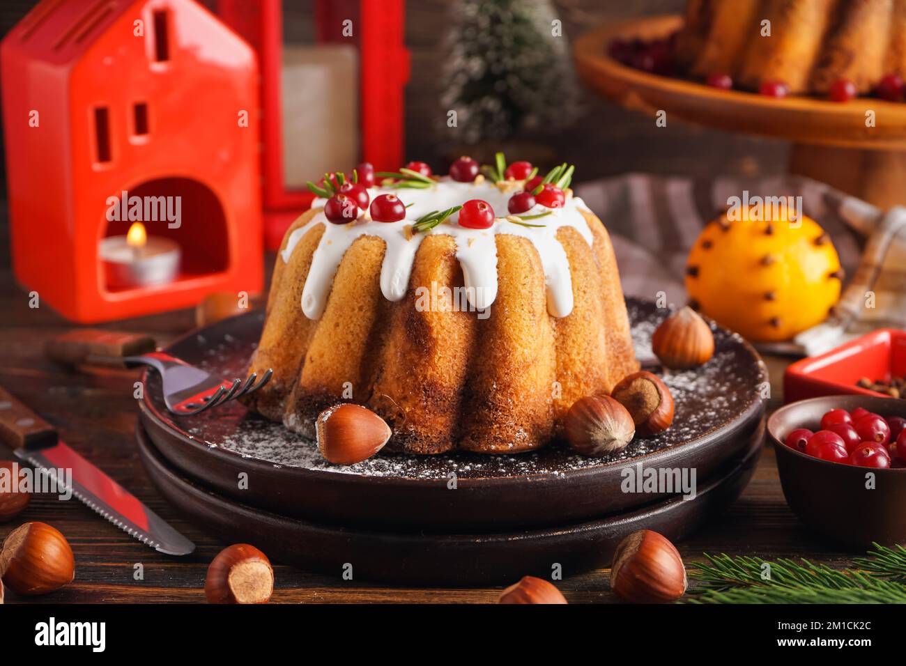 Plate with tasty Christmas cake and hazelnuts on wooden table Stock ...