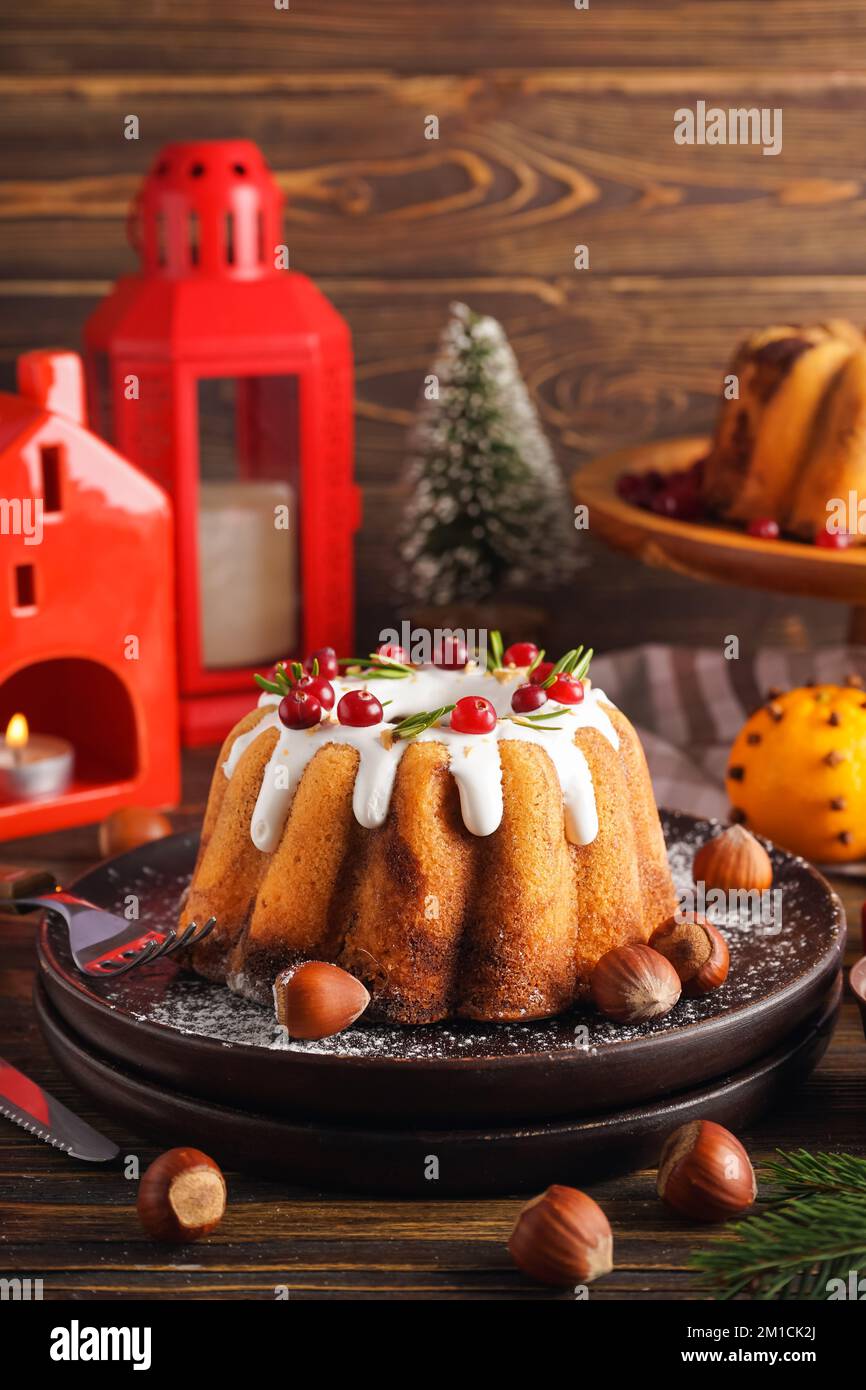 Plate with tasty Christmas cake and hazelnuts on wooden table Stock ...