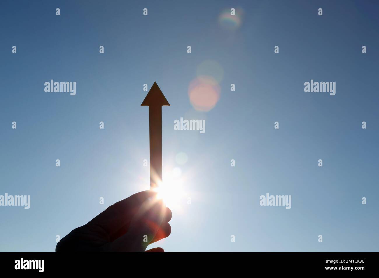 Hand choosing and holding an arrow rising high and stocks finance ...