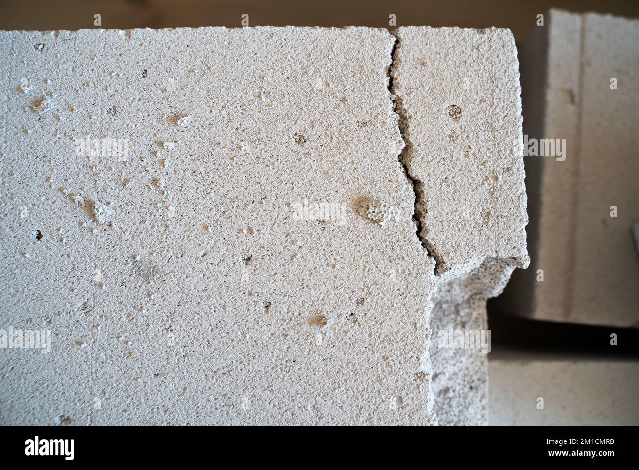 Cracked freshly delivered aerated concrete brick close-up. White porous ...