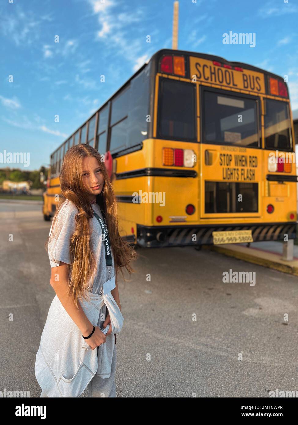 Beautiful teen girl getting on school bus Stock Photo - Alamy