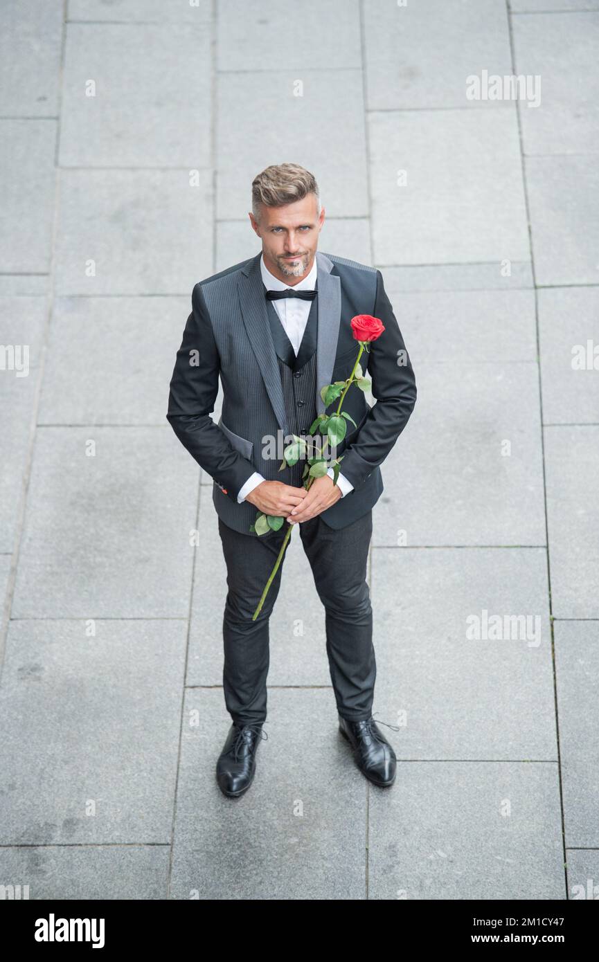 engagement date. mature tuxedo man celebrates engagement. man with rose ...
