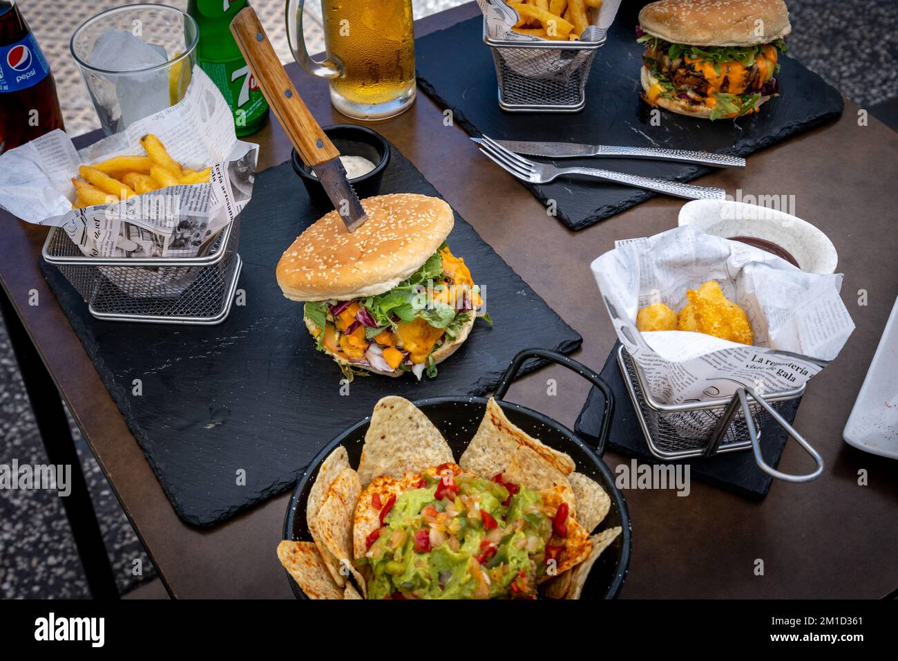 A closeup of nachos and burgers served with French fries and mozzarella ...