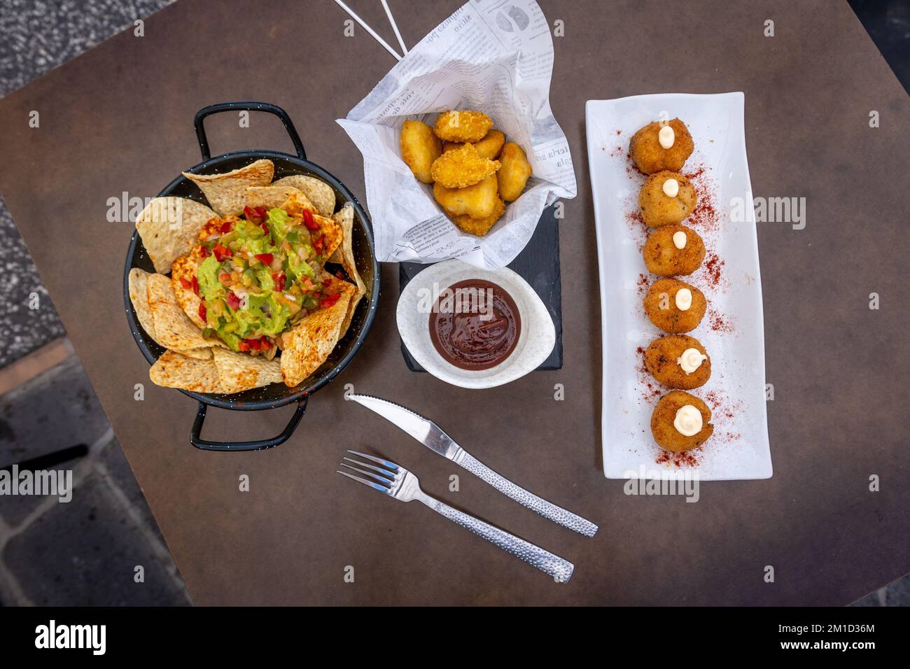 A top view of fried mozzarella balls served with ketchup and nachos in ...