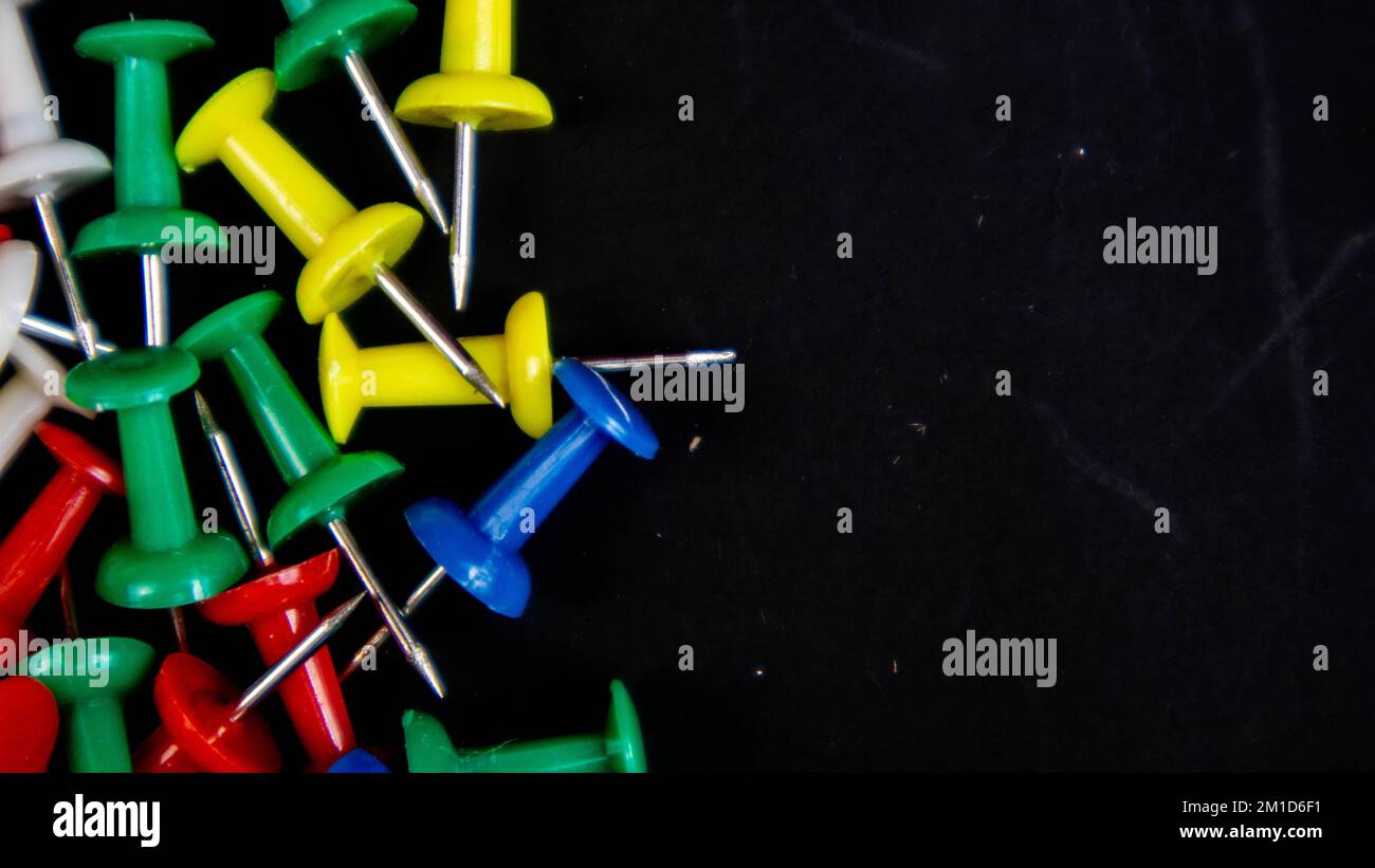 colorful thumbtacks on black background Stock Photo - Alamy