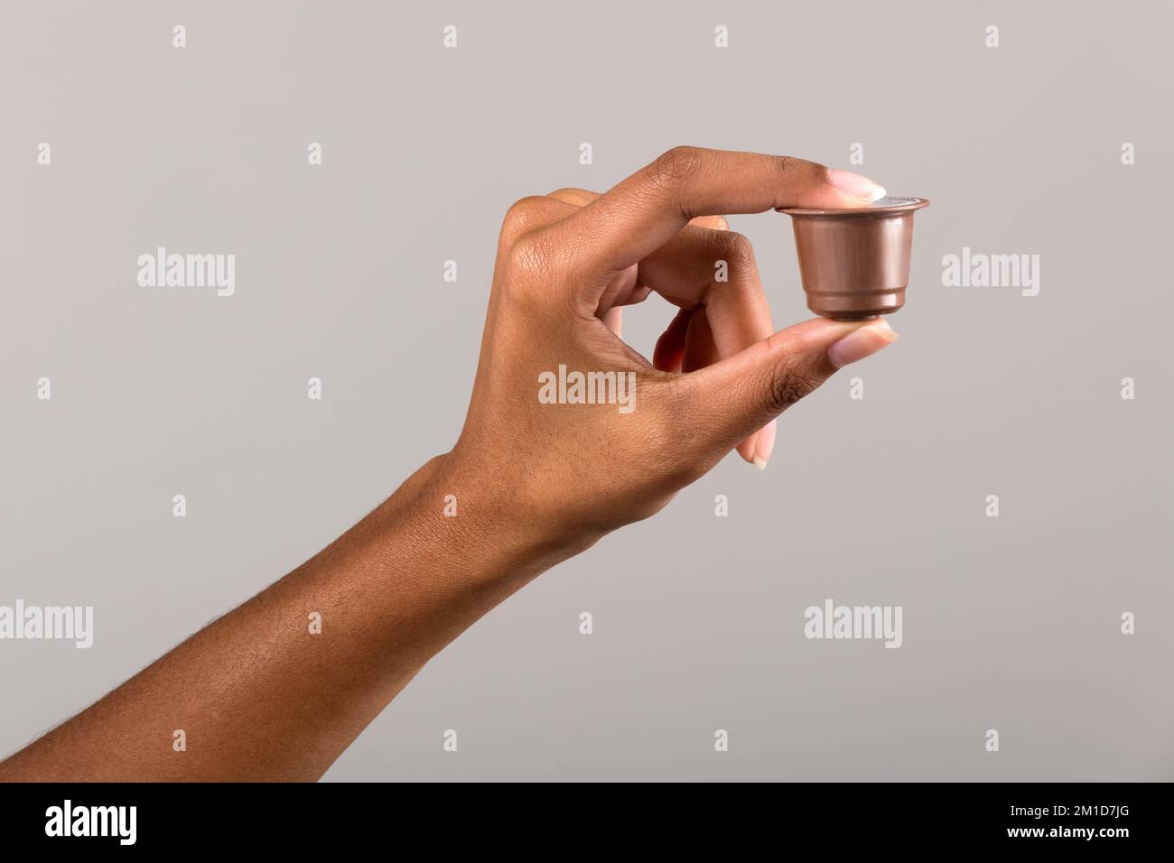Crop anonymous African American female demonstrating small brown ...