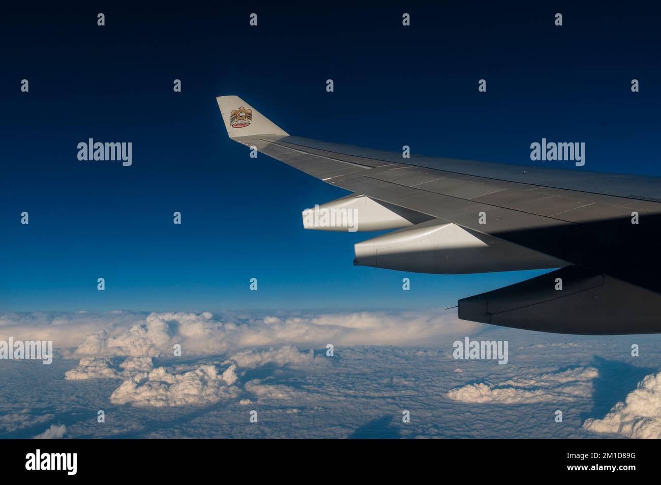 One wing of an Emirates Airline aeroplane above the clouds Stock Photo ...