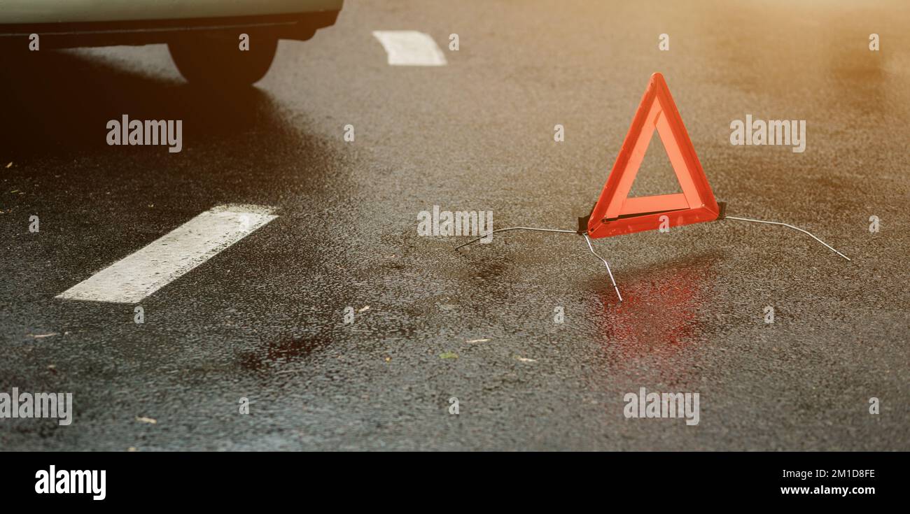Red emergency stop sign and broken car on the road. be careful on the ...